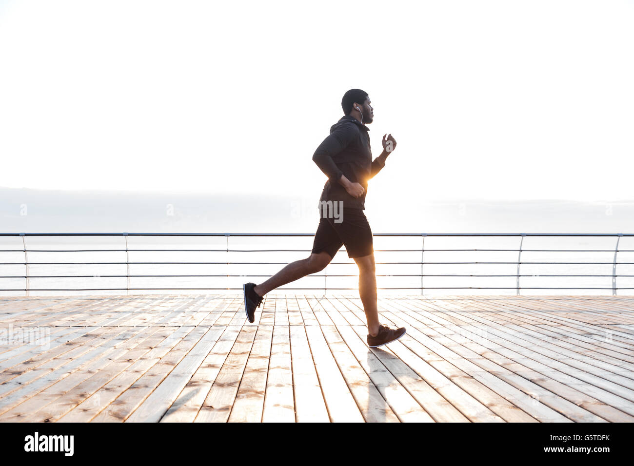 Full length of handsome african american young sportsman running on ...