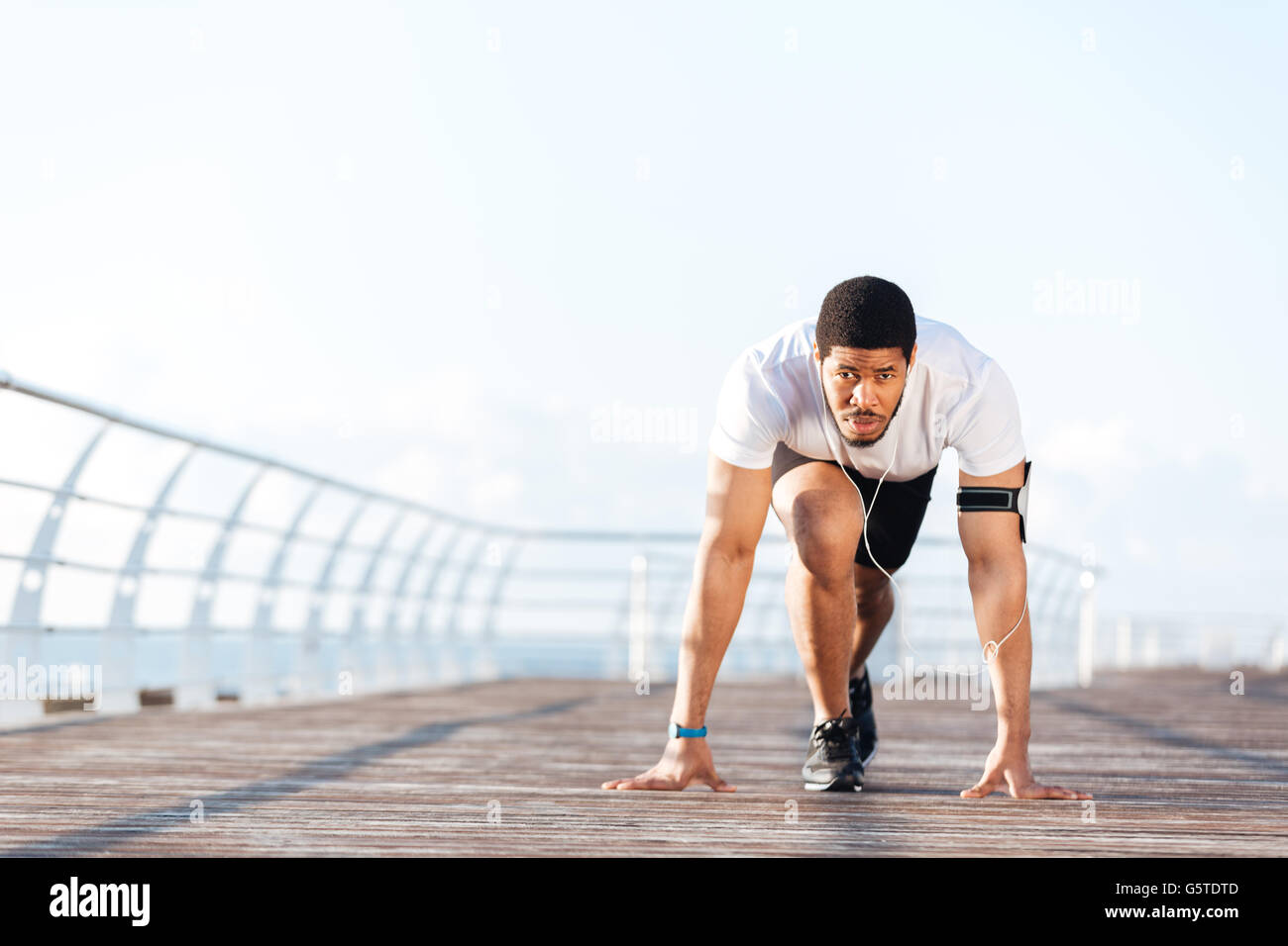 Portrait of focused african american sportsman in running start ...