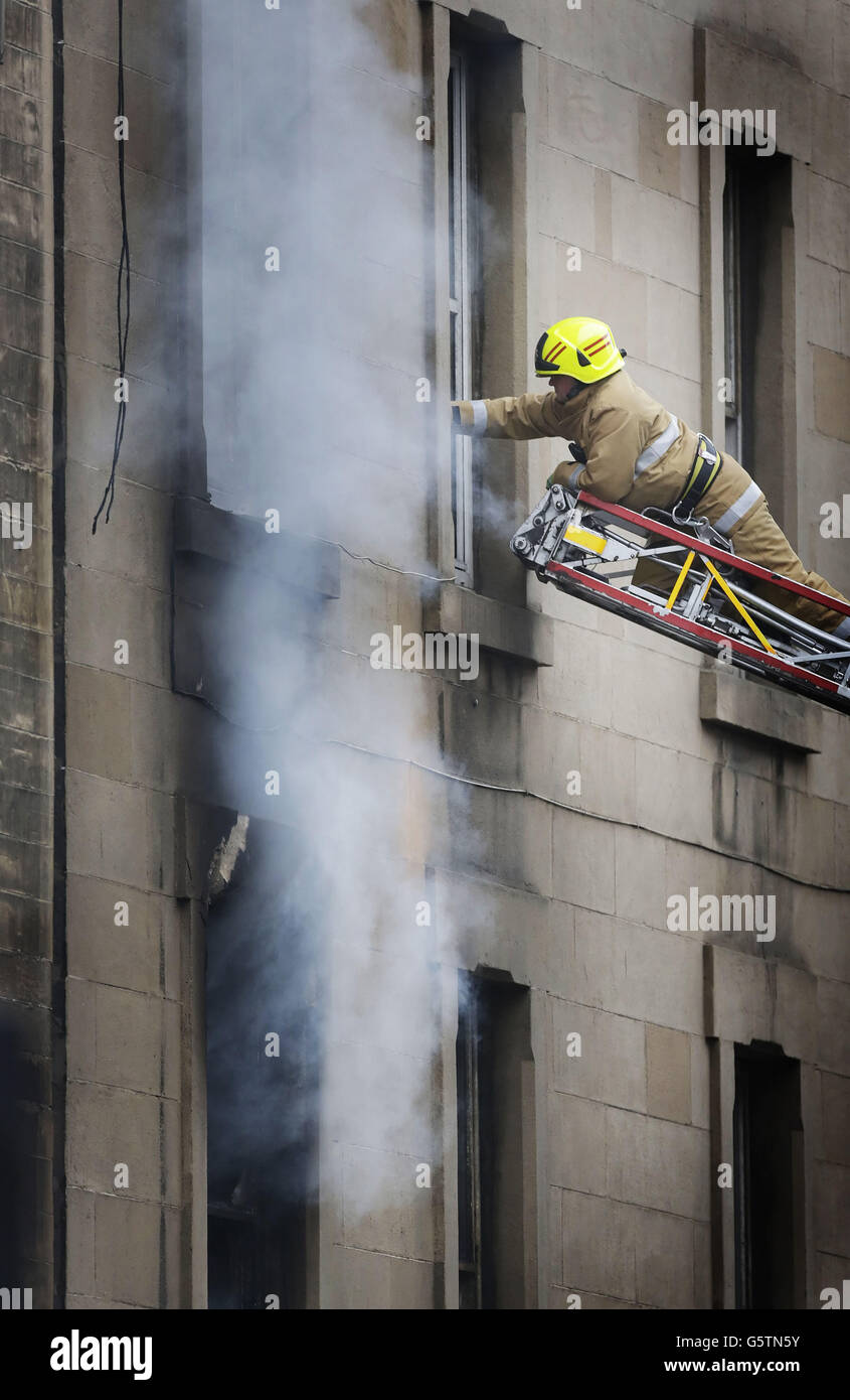 A fireman helps a man from a window at the scene of a fire in the ...