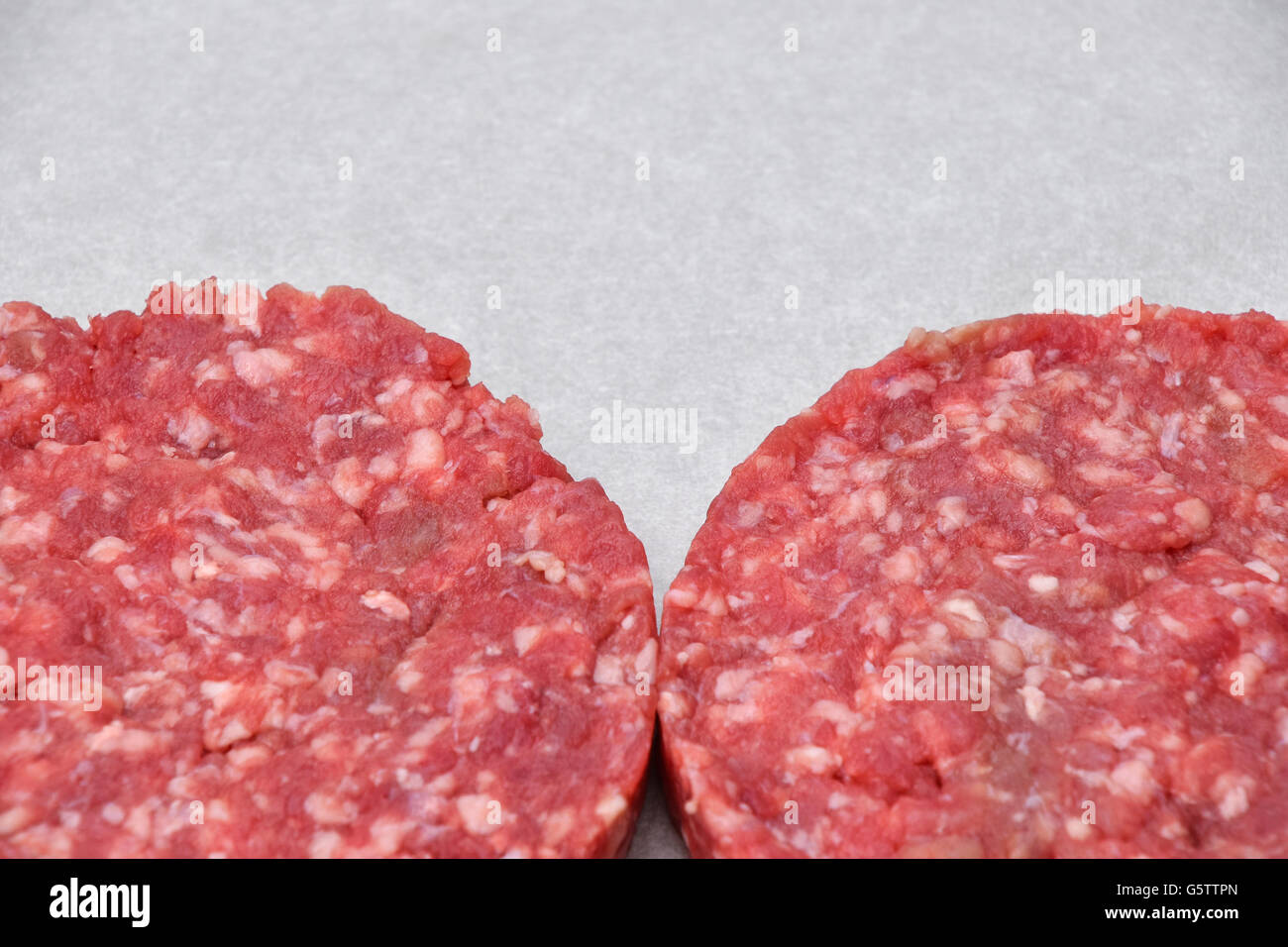 Raw red meat burgers for hamburgers of minced ground beef or pork on ...