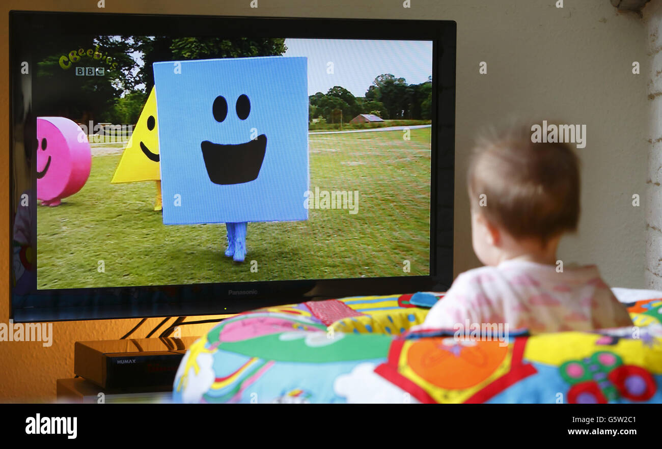 Baby watches the cbeebies television channel on flat screen television ...