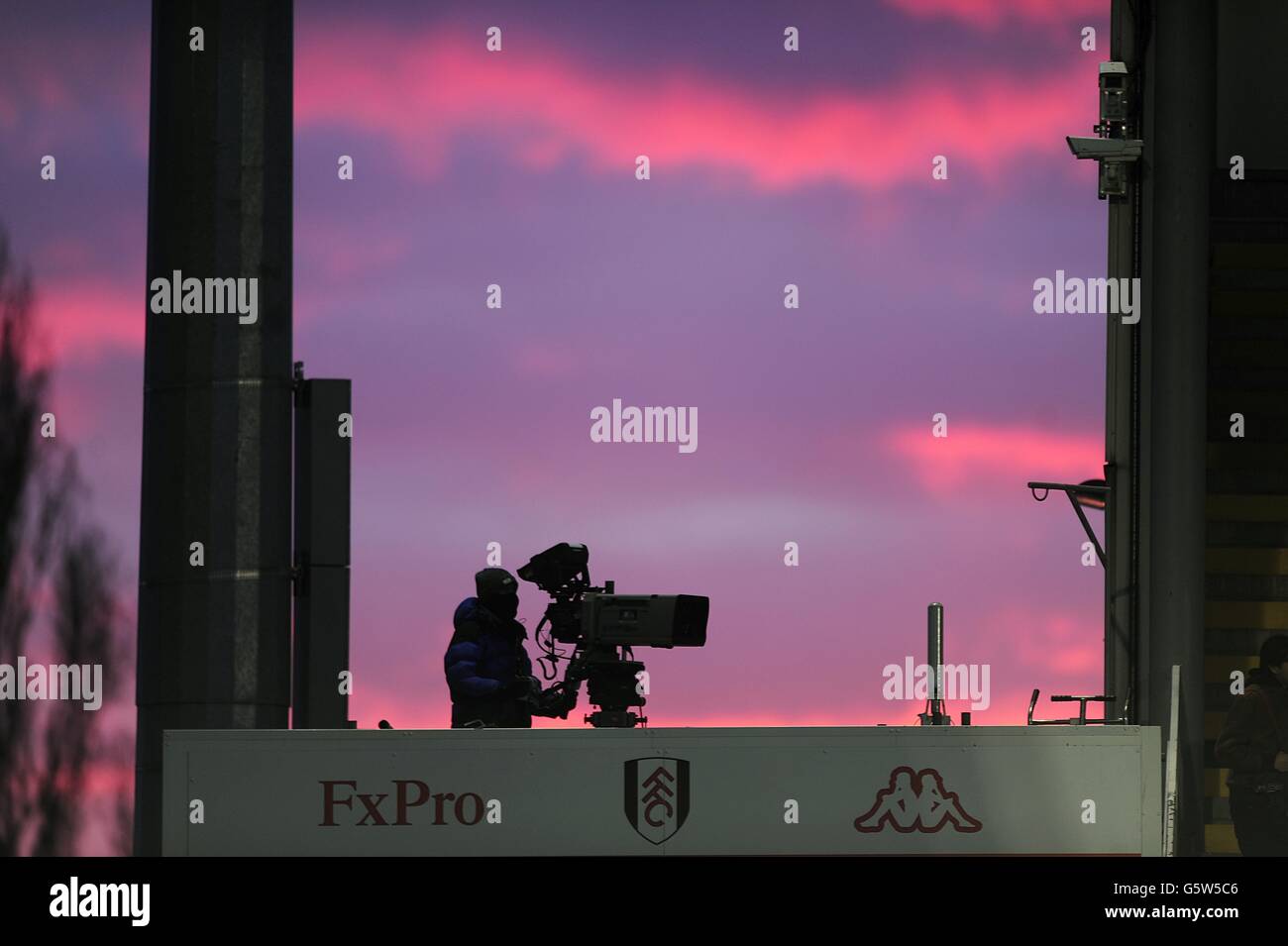 General view of a television cameraman seen in front of a sunset sky ...
