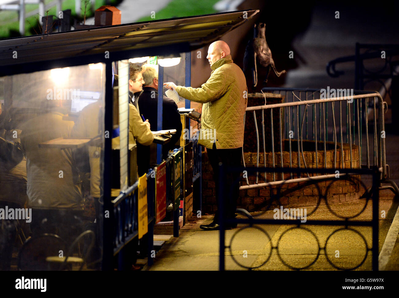 Greyhounds - Brighton & Hove Greyhound Stadium. A man places a bet at a ...