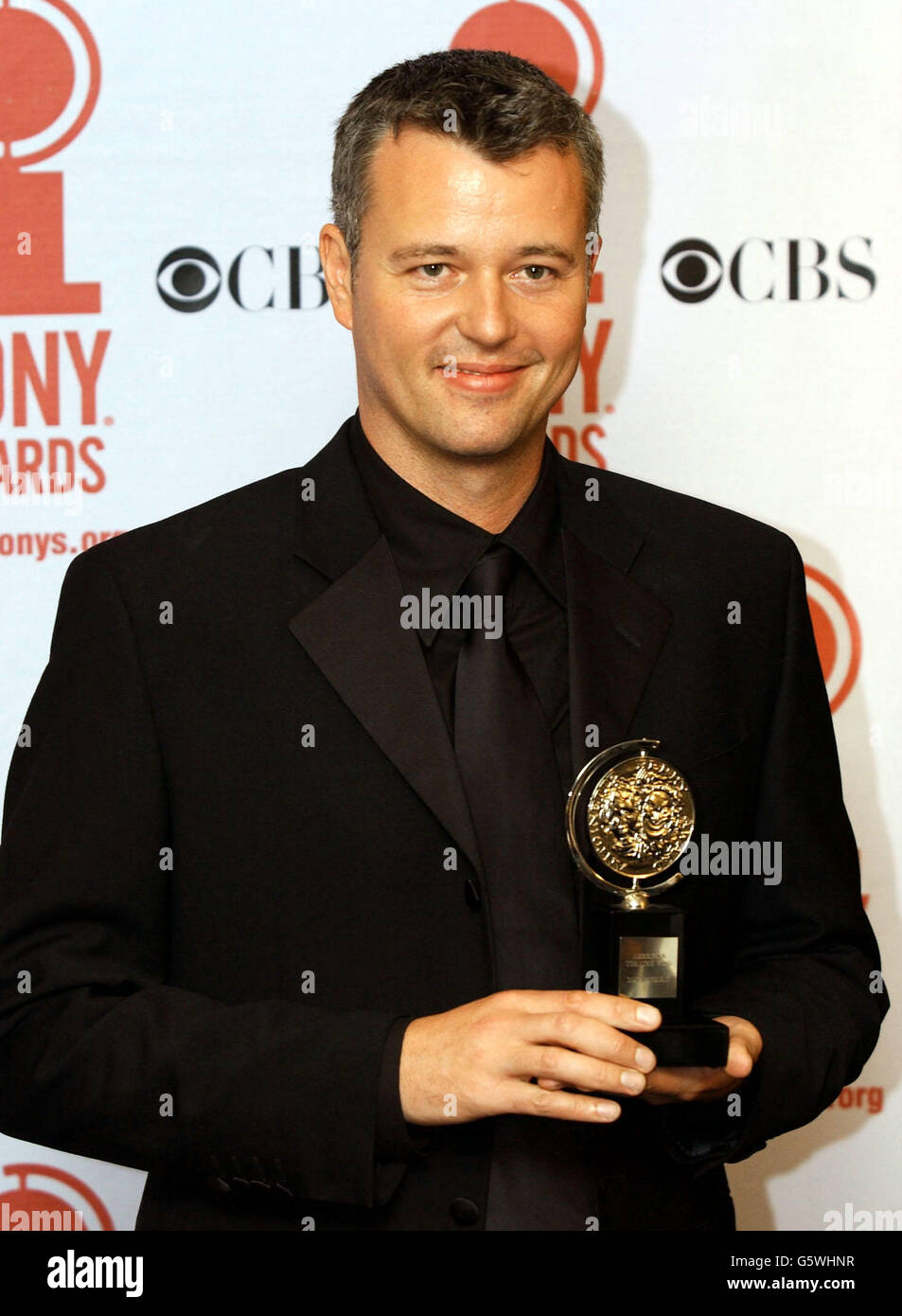 Celebrity 1 2 half length smiling holding award black suit hi-res stock ...