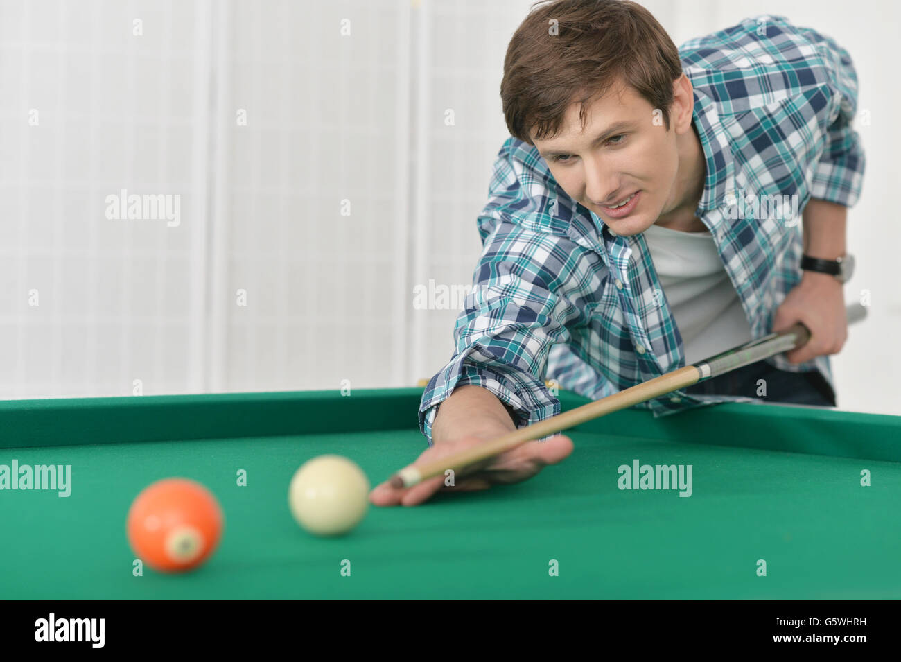Young man playing billiards in billiard club Stock Photo - Alamy