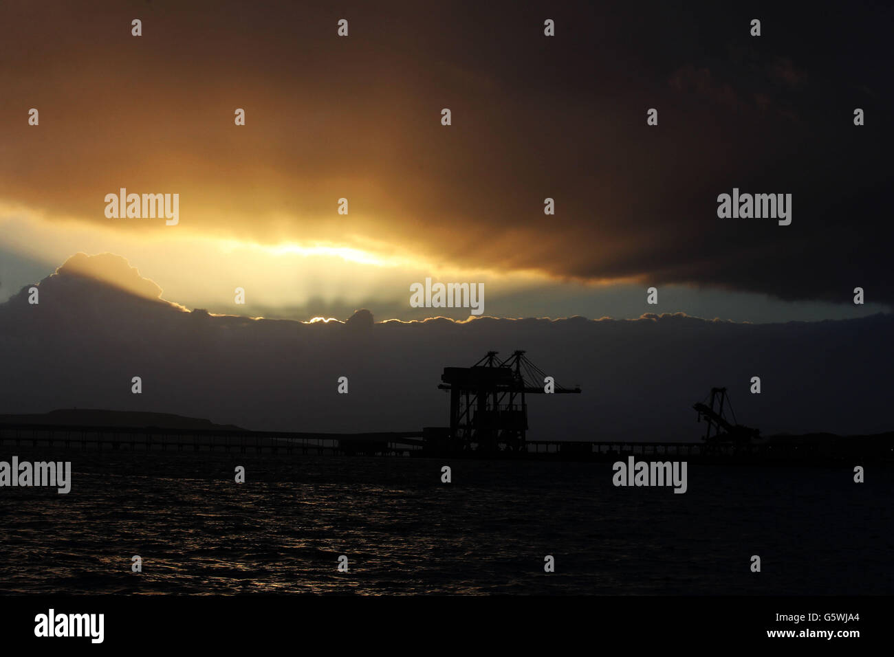 The sun sets over Hunterston Terminal, a coal-handling port located at ...