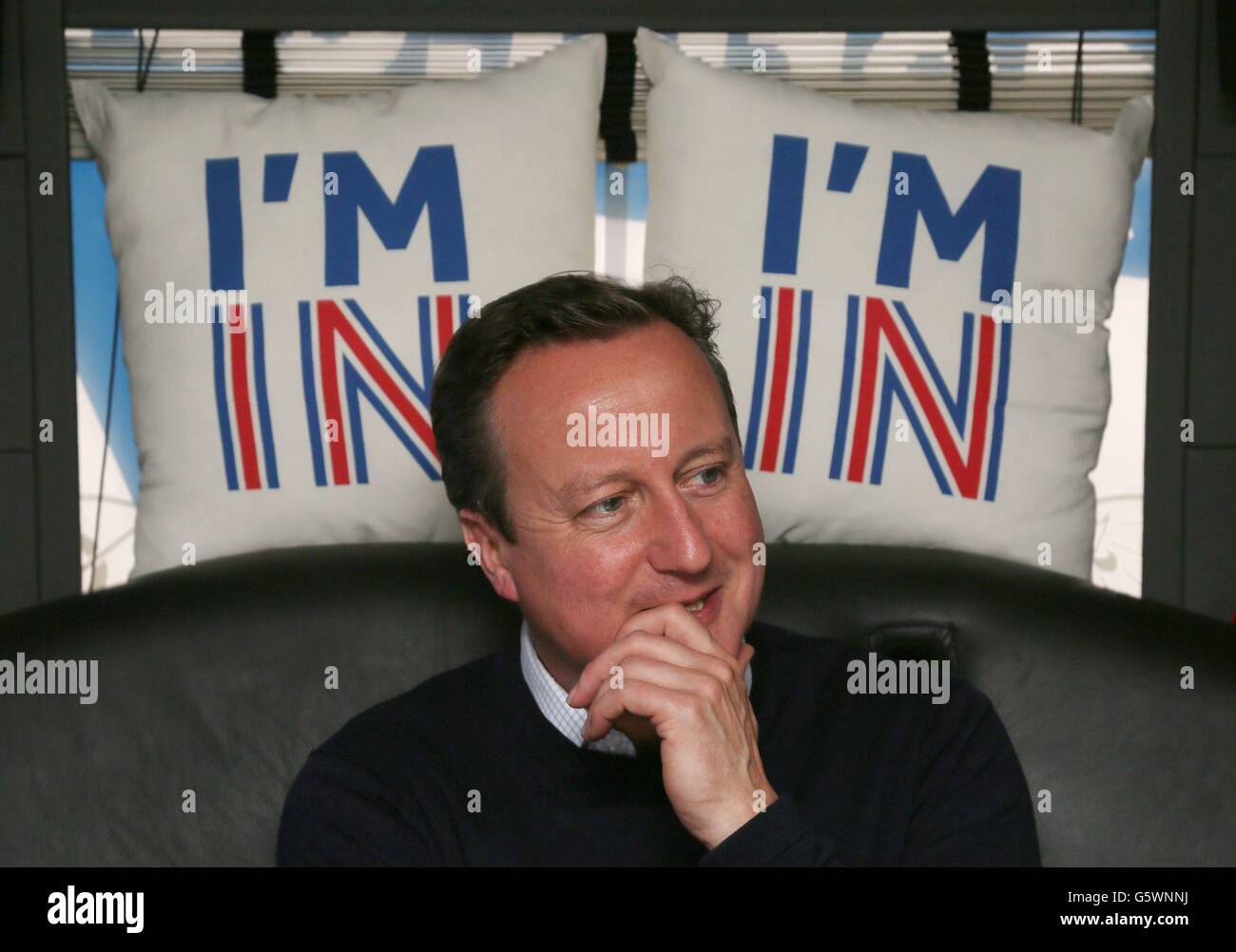 Prime Minister David Cameron reacts as he travels on his campaign bus ...