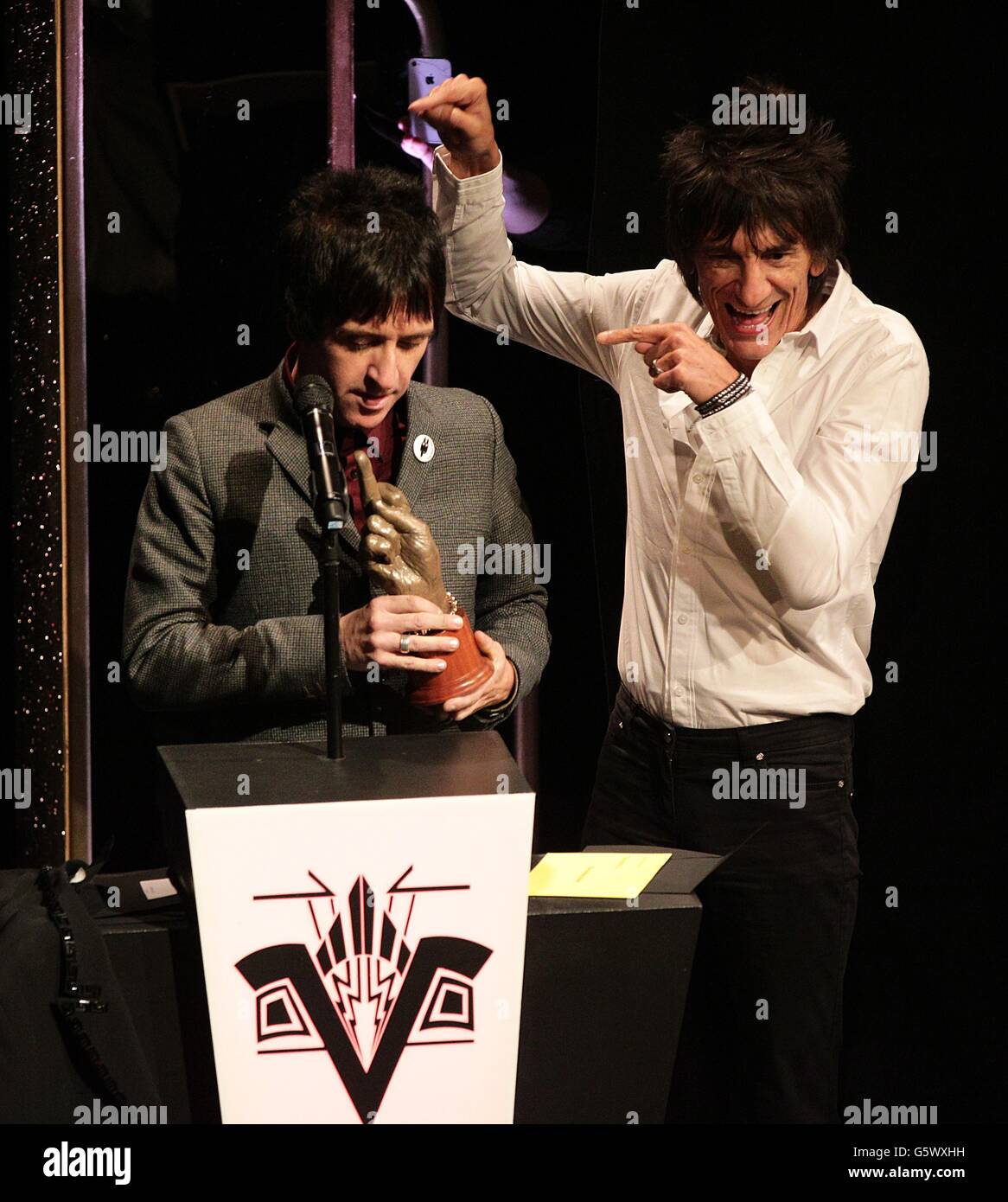 Johnny Marr (left) collects the Godlike Genius Award on stage alongside ...