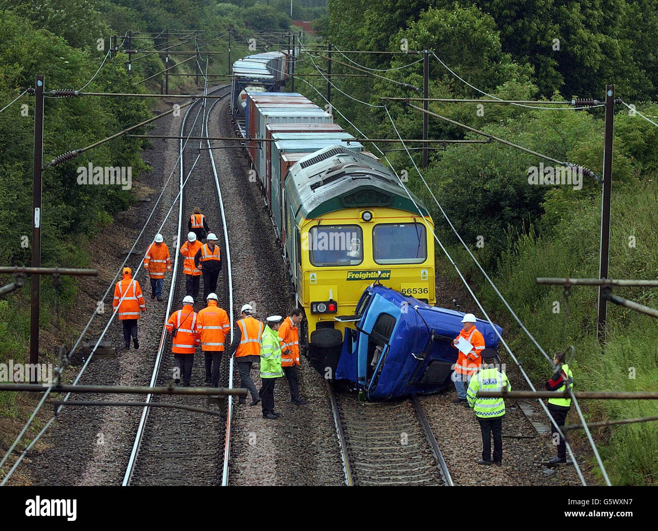 Investigators and emergency service personnel inspect the scene at ...