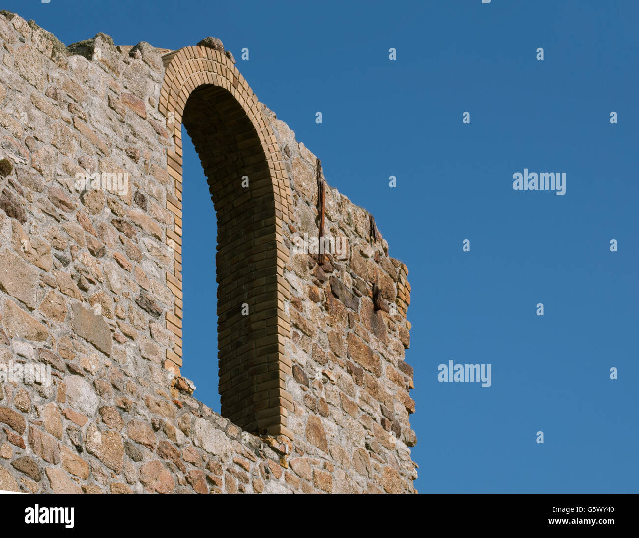 Window arch remains of ruined building against blue sky Stock Photo - Alamy
