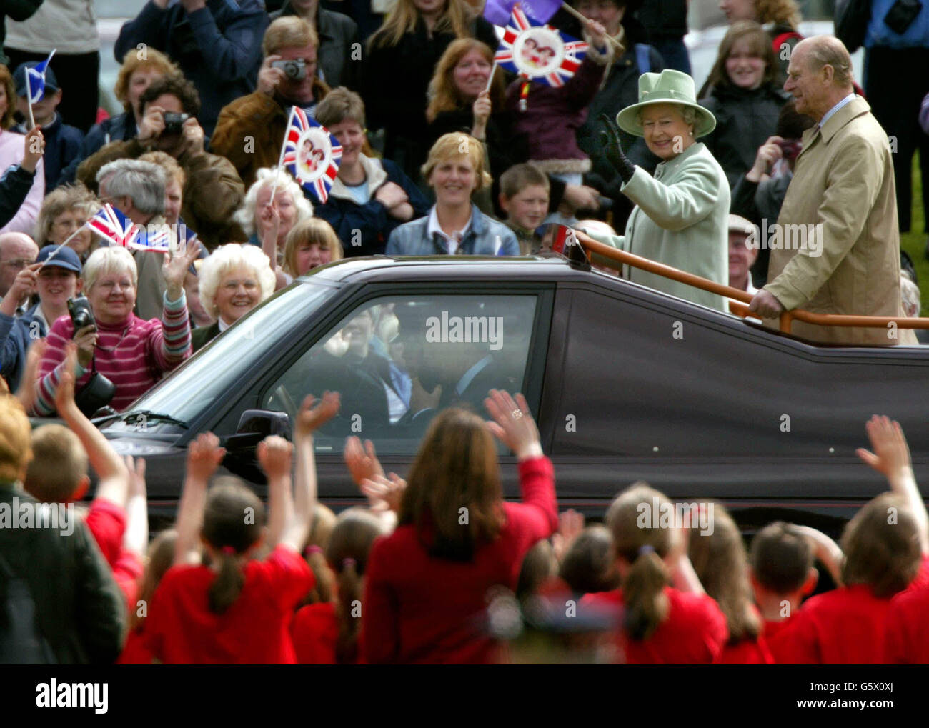 Britain's Queen Elizabeth and the Duke of Edinburgh wave at gathered ...