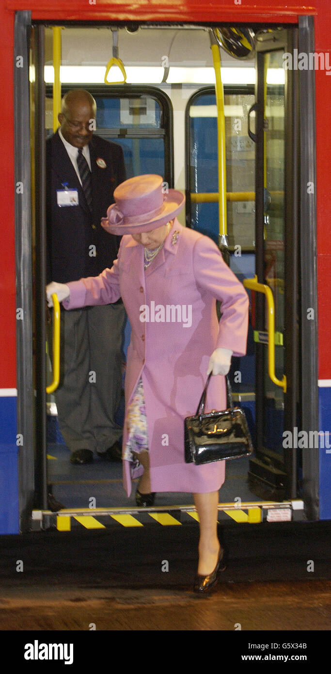 Queen Elizabeth II alights from a double decker bus, watched by driver ...