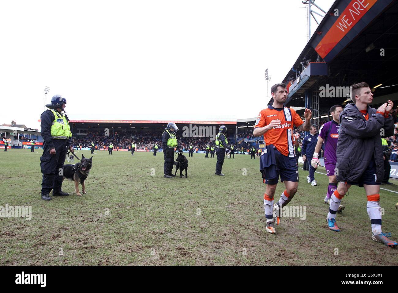 Police officers and dogs on the pitch as Luton Town players applaud the ...