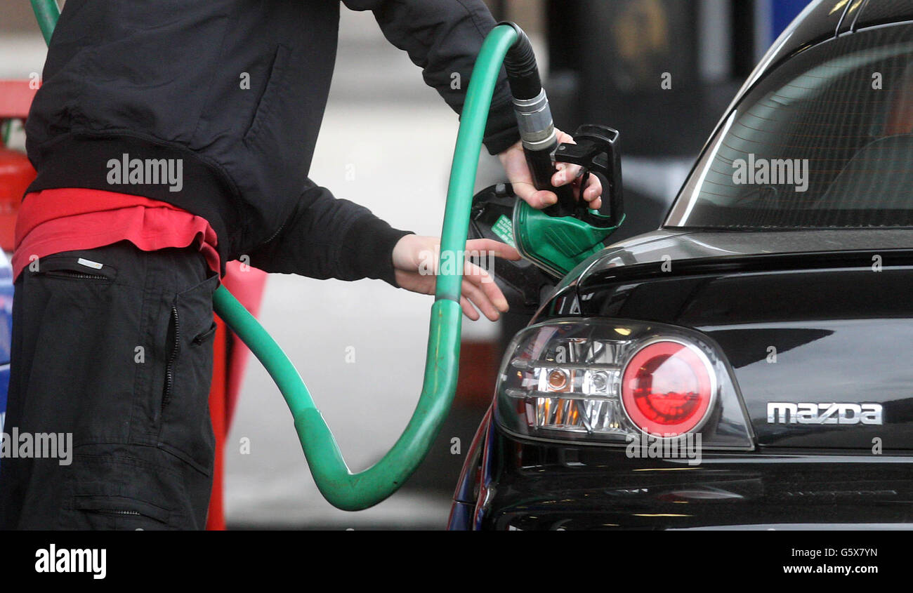 A generic photo of a person using petrol pump at a petrol station in ...