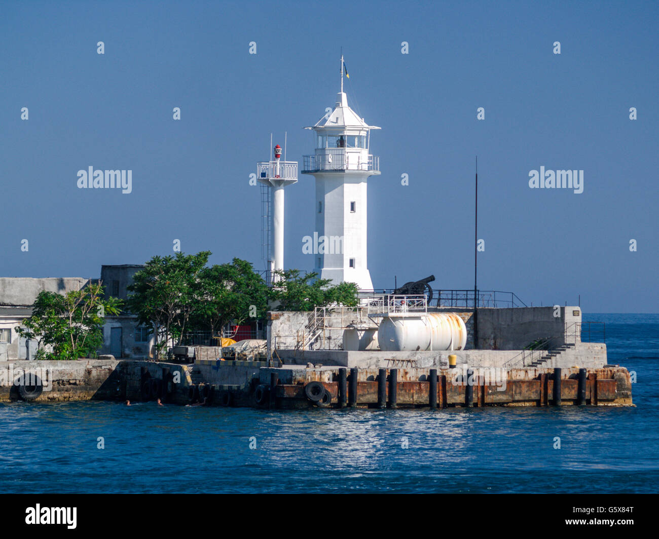 White lighthouse on the beach in a clear summer day under blue clear ...