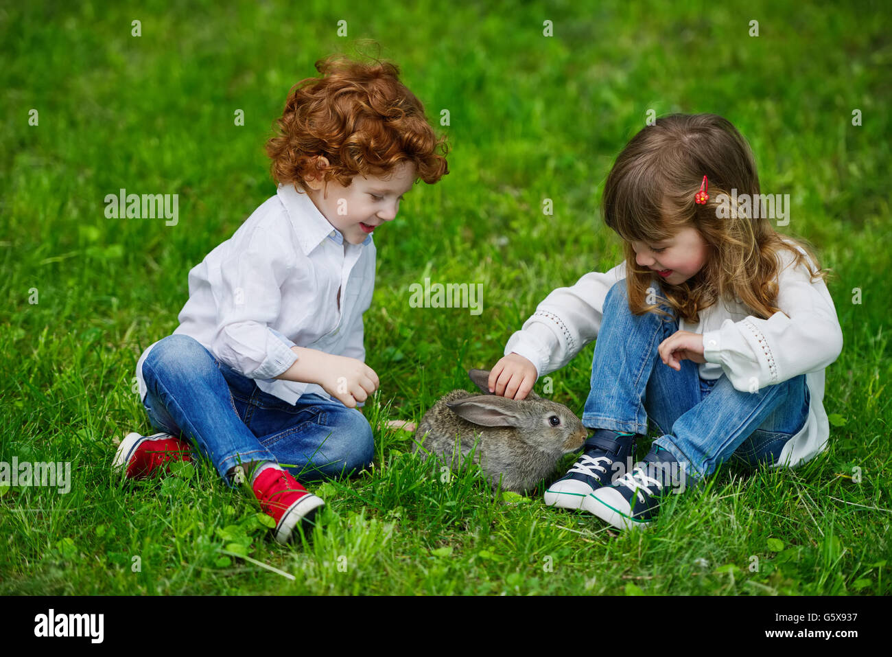 boy and girl playing with rabbit Stock Photo - Alamy