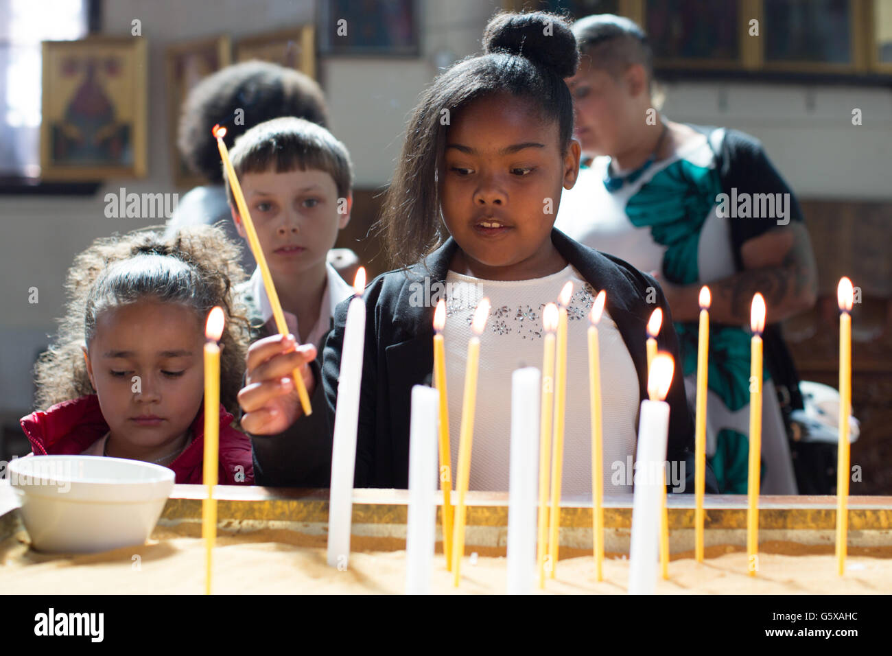 Children lighting candles in a church Stock Photo - Alamy