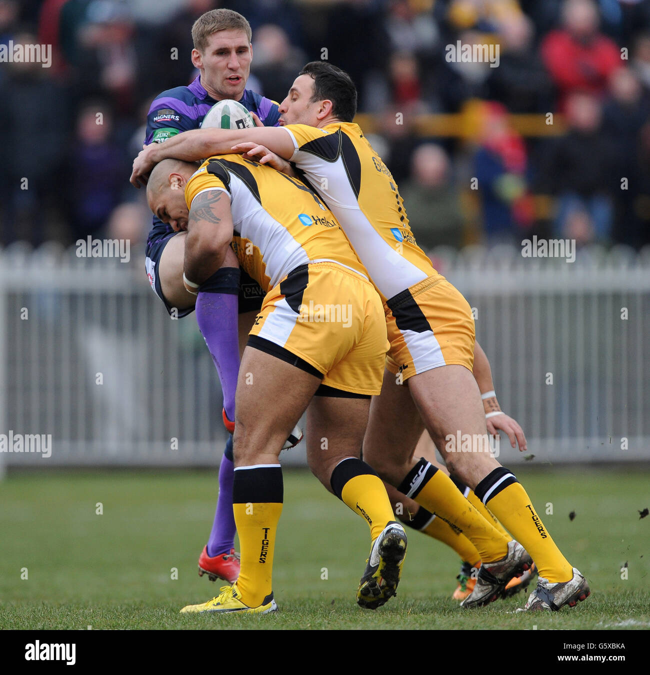 Castleford Tigers' Jake Webster (centre) and Lee Gilmour (right) tackle ...