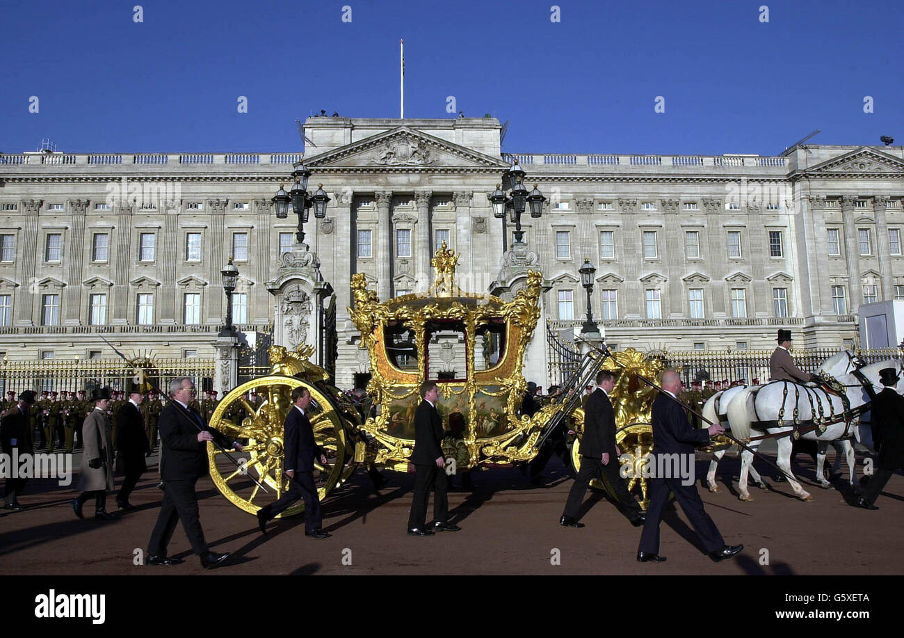 The Gold State Coach makes its way past Buckingham Palace during a ...