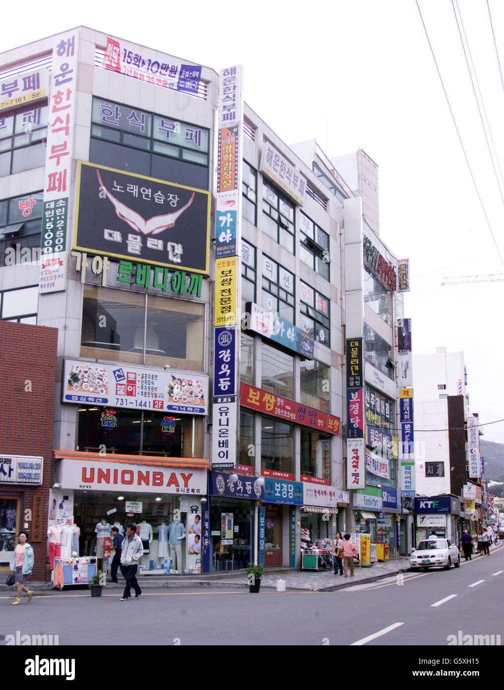 A street in Busan where the buildings are covered in various signs and ...