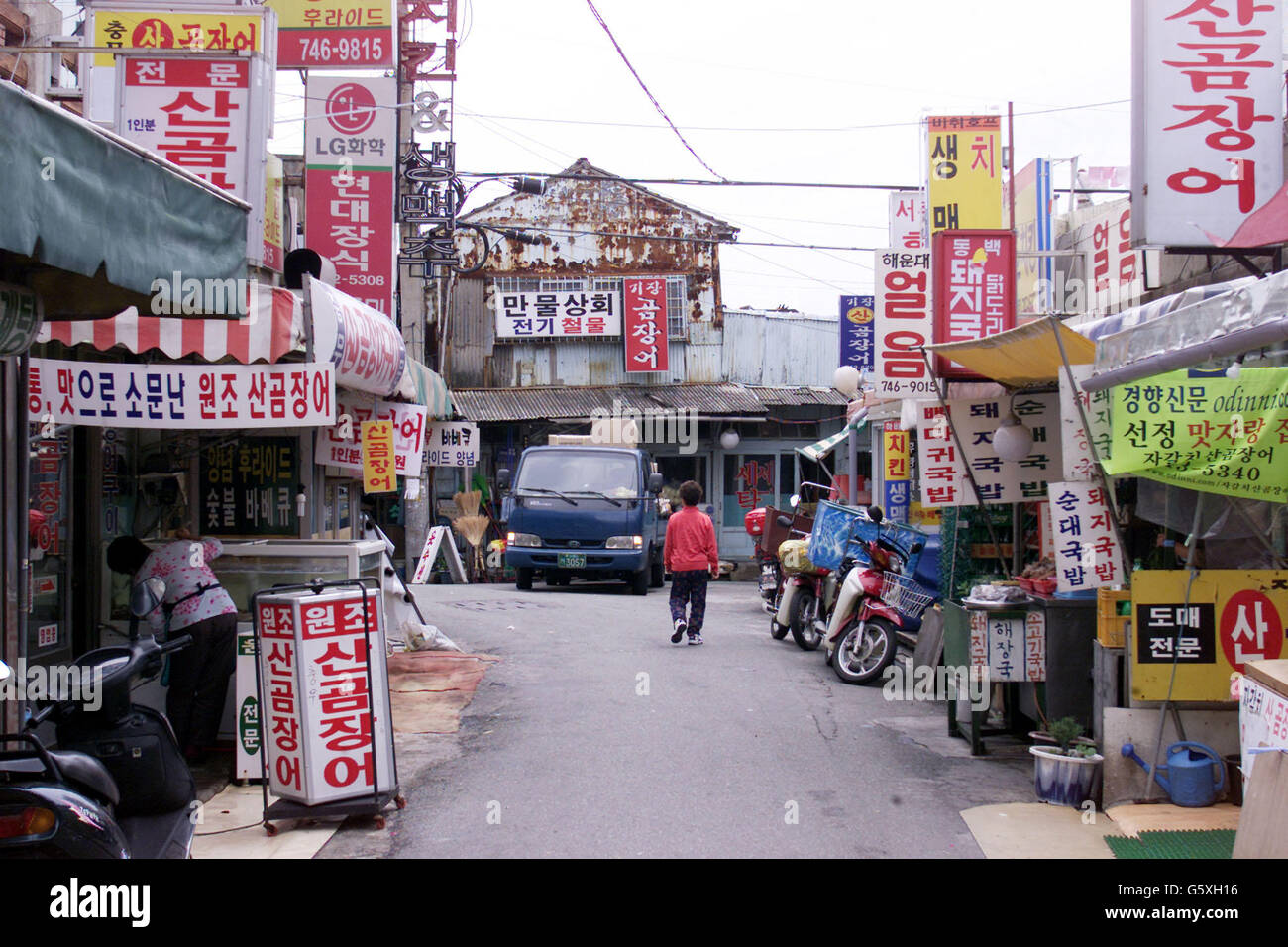Small shops and market stalls line this street in Busan where the ...