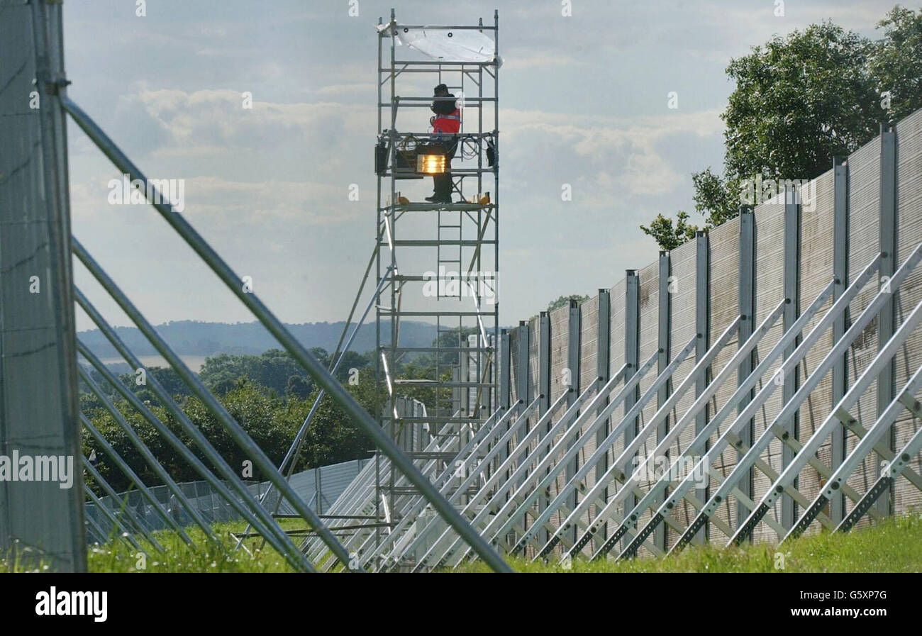 Security officer on watchtower keeps lookout on the perimeter fence hi ...