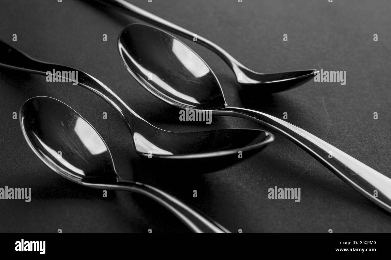 Set of four spoons, different sizes on black background Stock Photo - Alamy