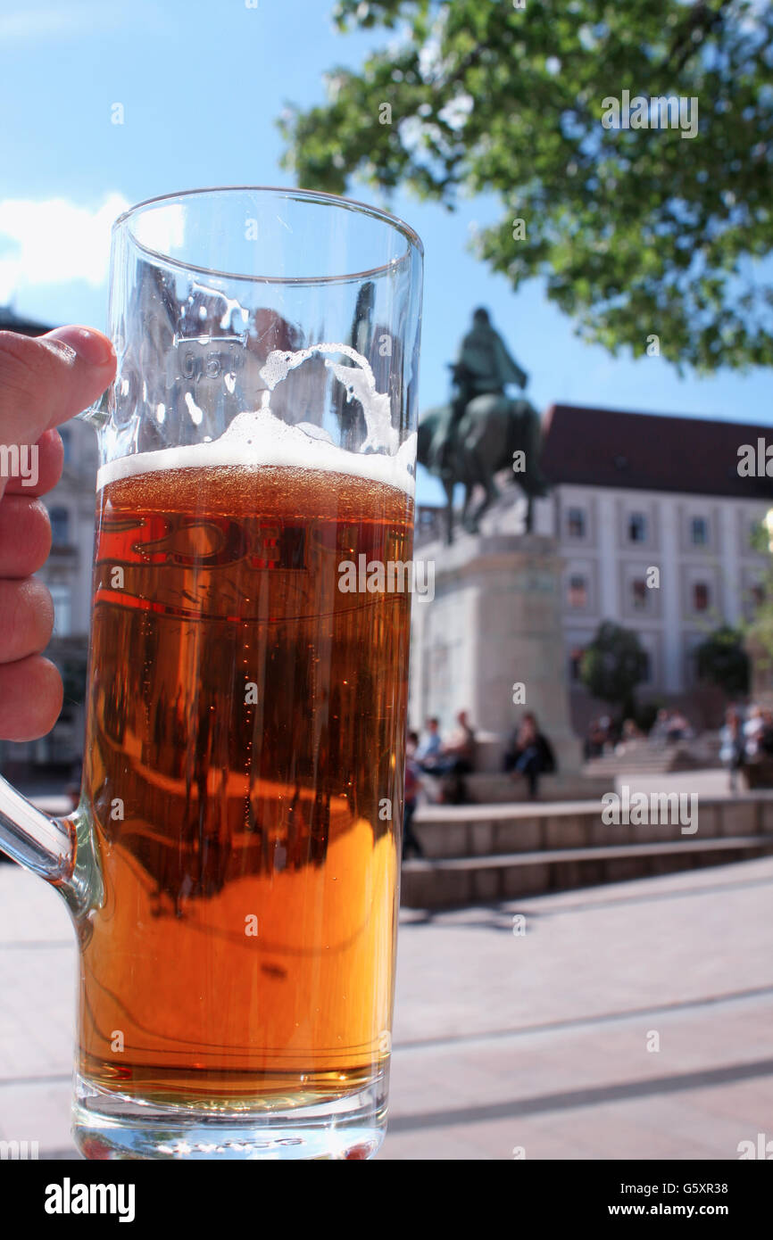 Closeup of a male hand holding up a glass of beer Stock Photo - Alamy