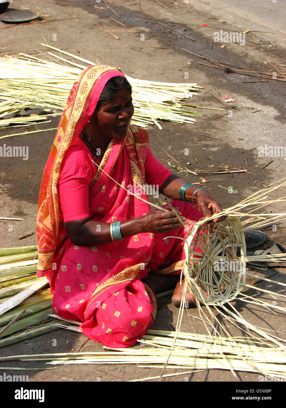 A poor Indian woman making wick baskets for a living Stock Photo - Alamy