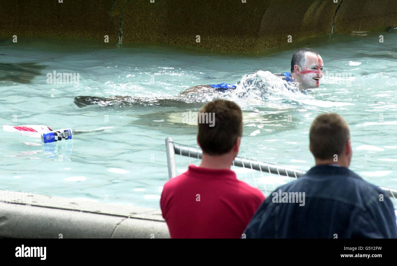 An English football fan goes for a swim in the pool of a fountain in ...