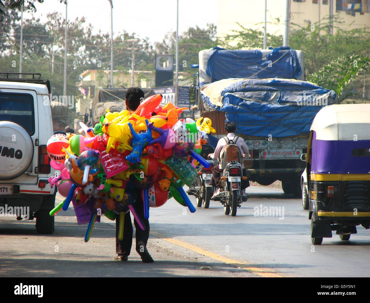 A balloon seller walks on a busy street in India Stock Photo - Alamy