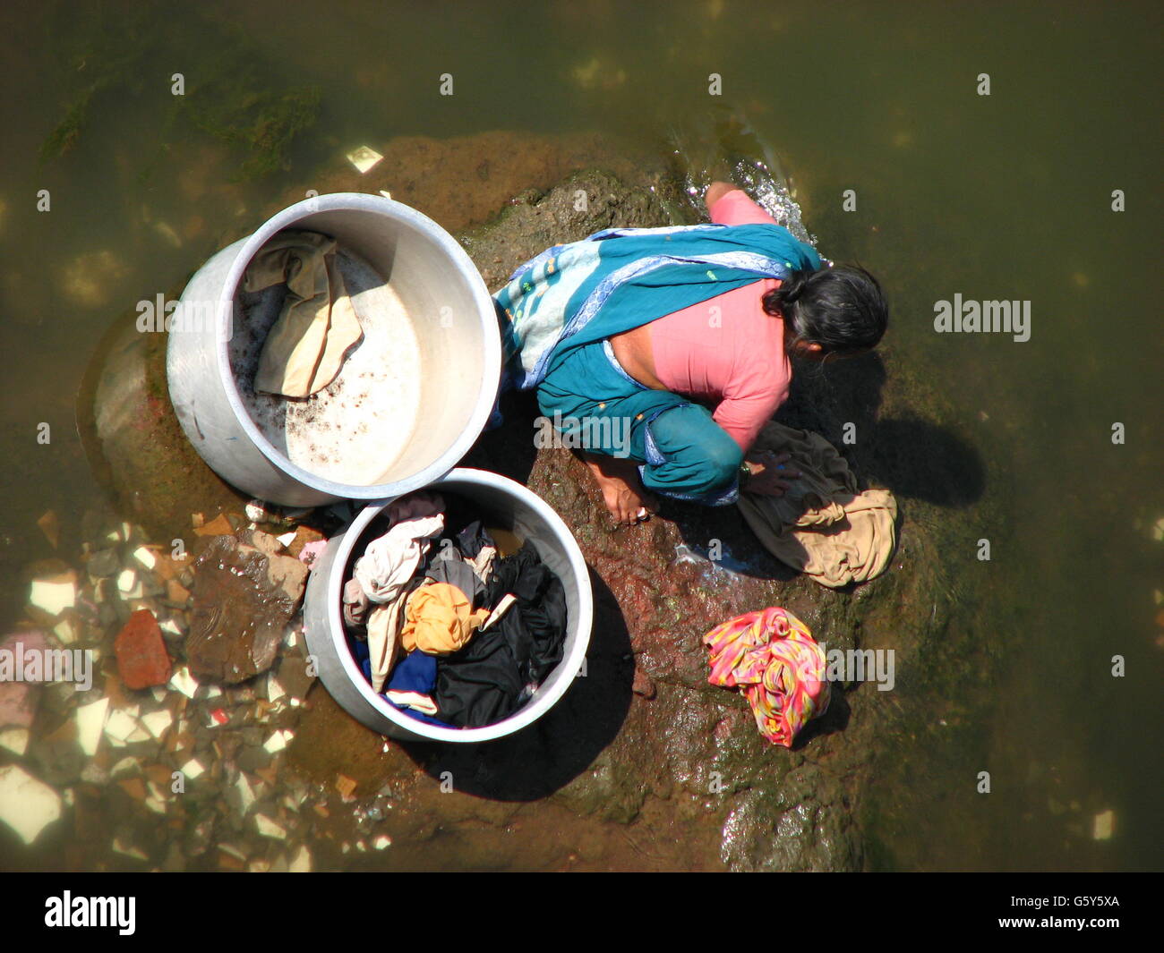 Old poor woman doing her laundry on a riverbank Stock Photo - Alamy