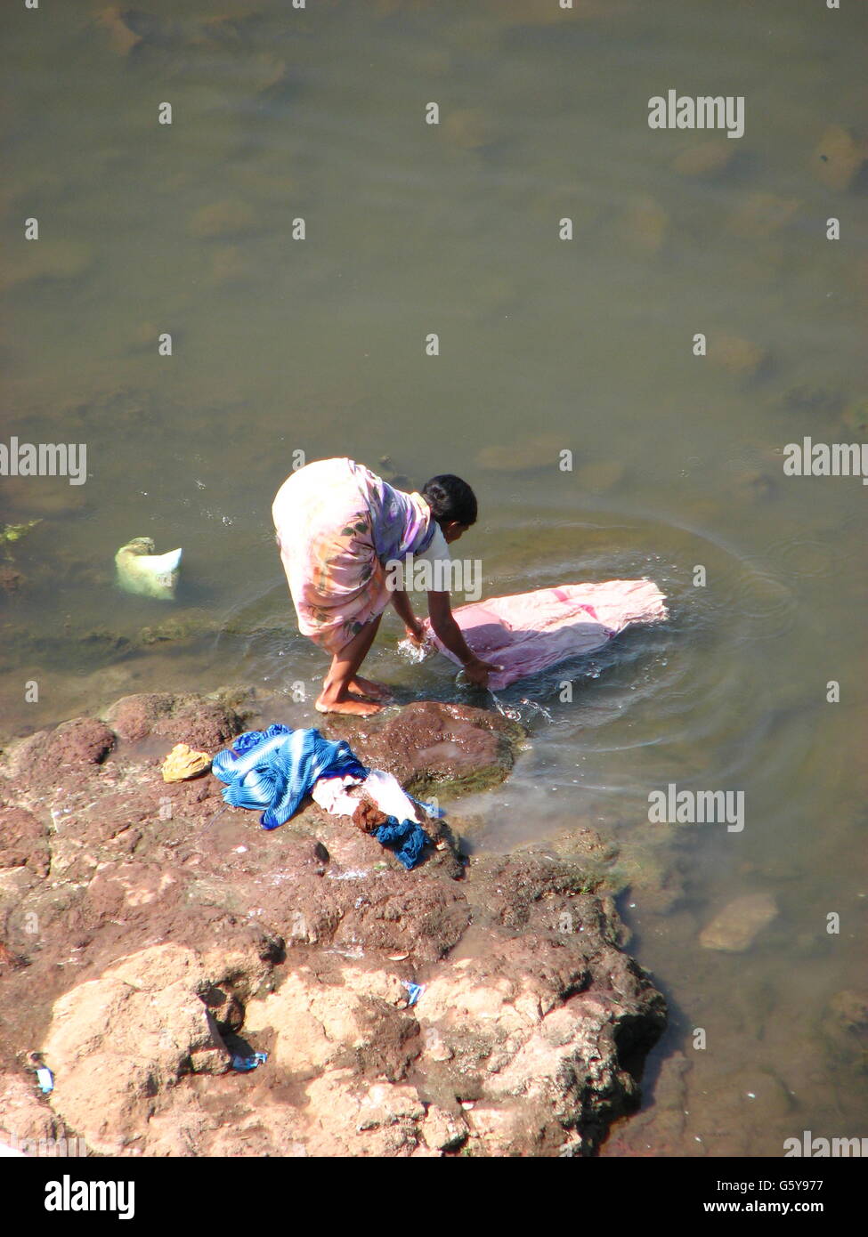 A poor woman washing her clothes in an Indian river Stock Photo ...