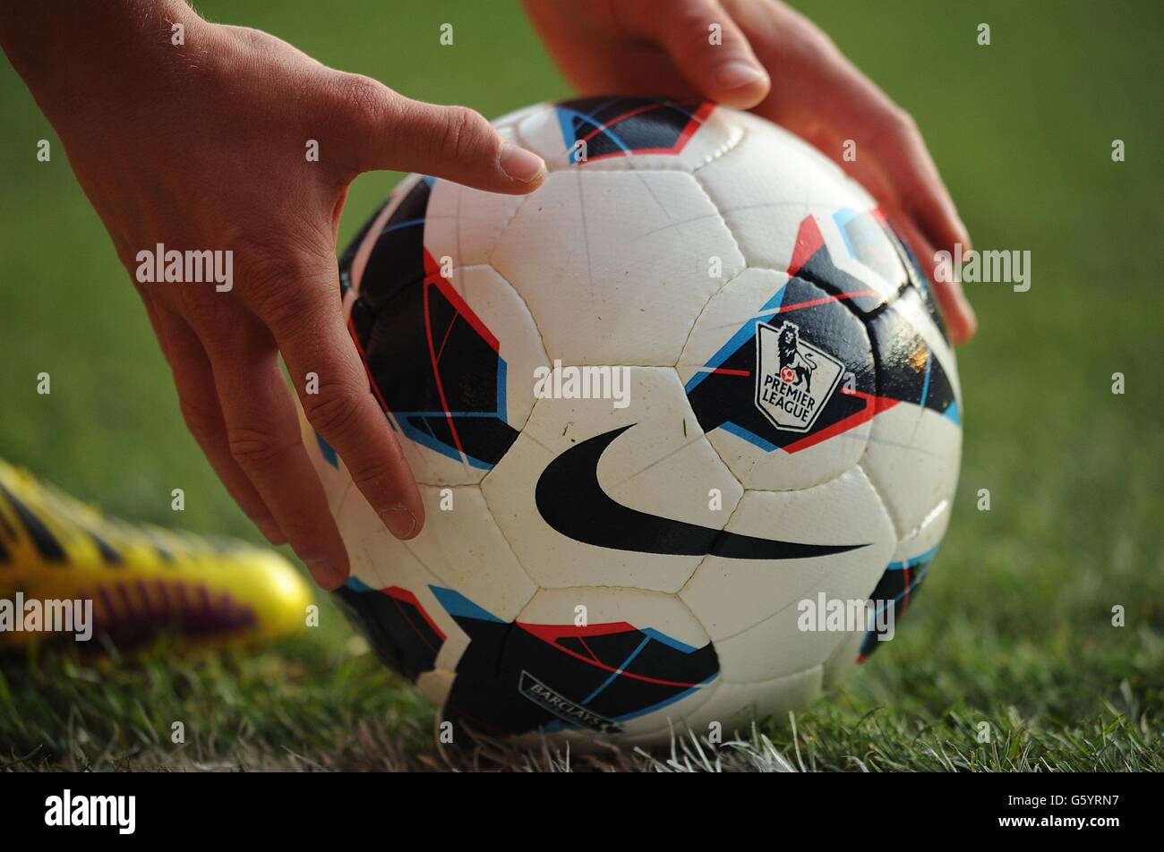A player places an official Nike Premier League matchball on the pitch ...