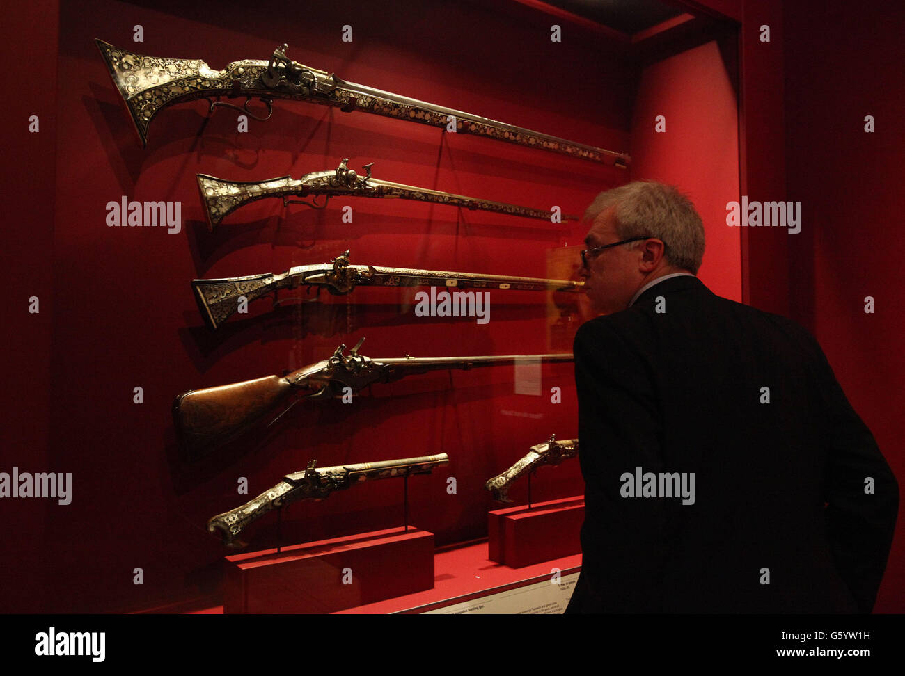 A visitor looks at a selection of firearms on display at the Treasures ...