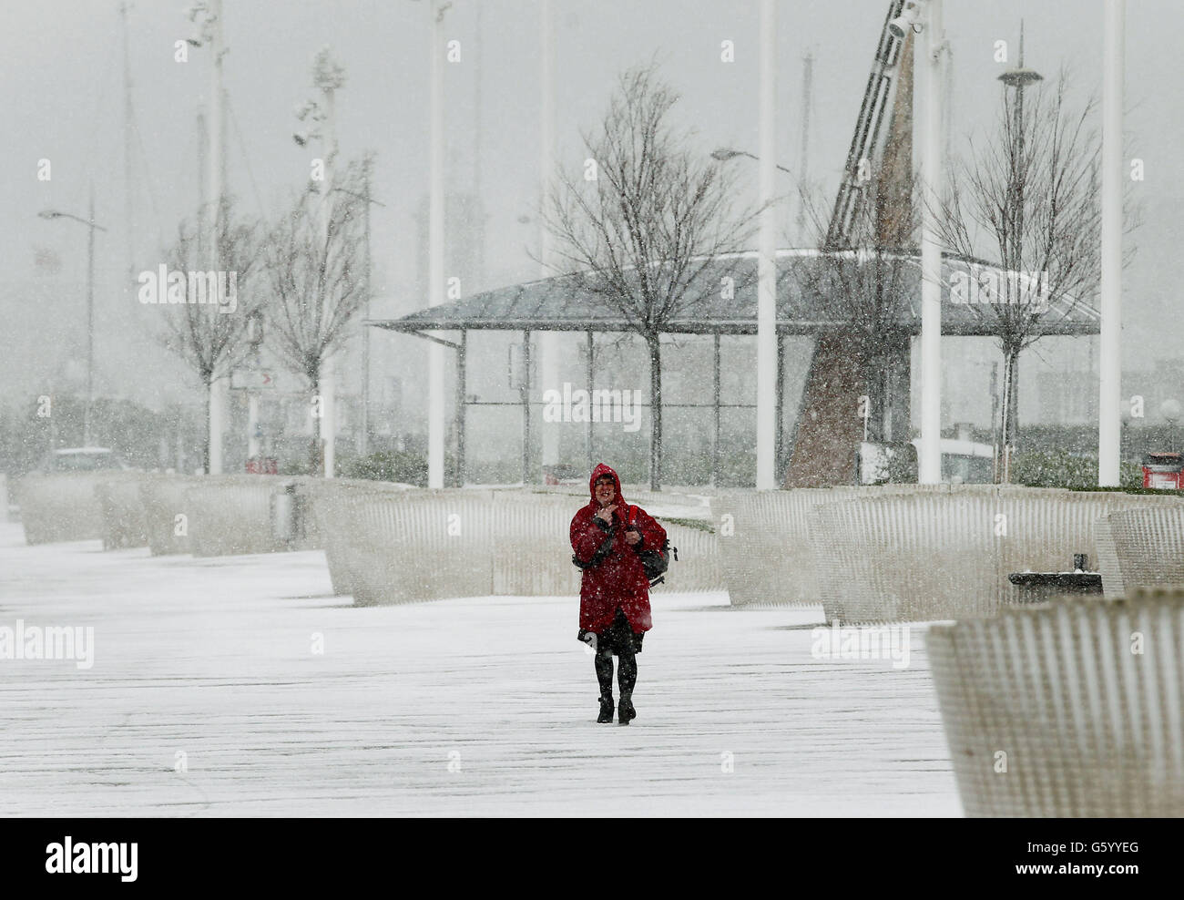 A lady walks along a snowy promenade in Dover, Kent, as winter weather ...