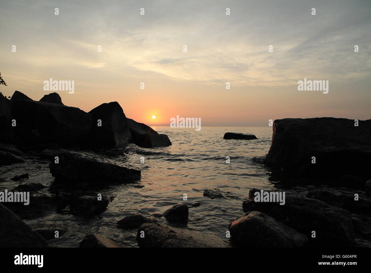Sunrise behind rocks Stock Photo - Alamy