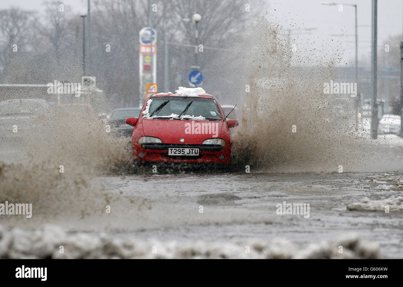 A car splashes through water in Shotton, North Wales, as drains ...