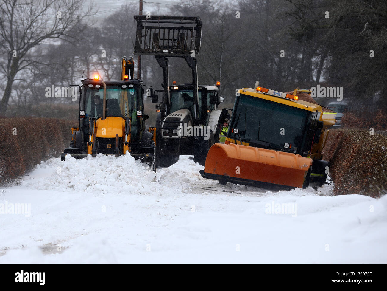 A digger clears snow from the road after a gritting vehicle got stuck ...