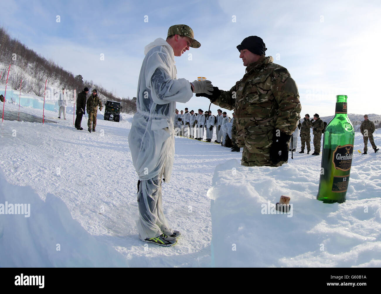 A Marine takes a drink of whisky after he completed the ice breaking ...