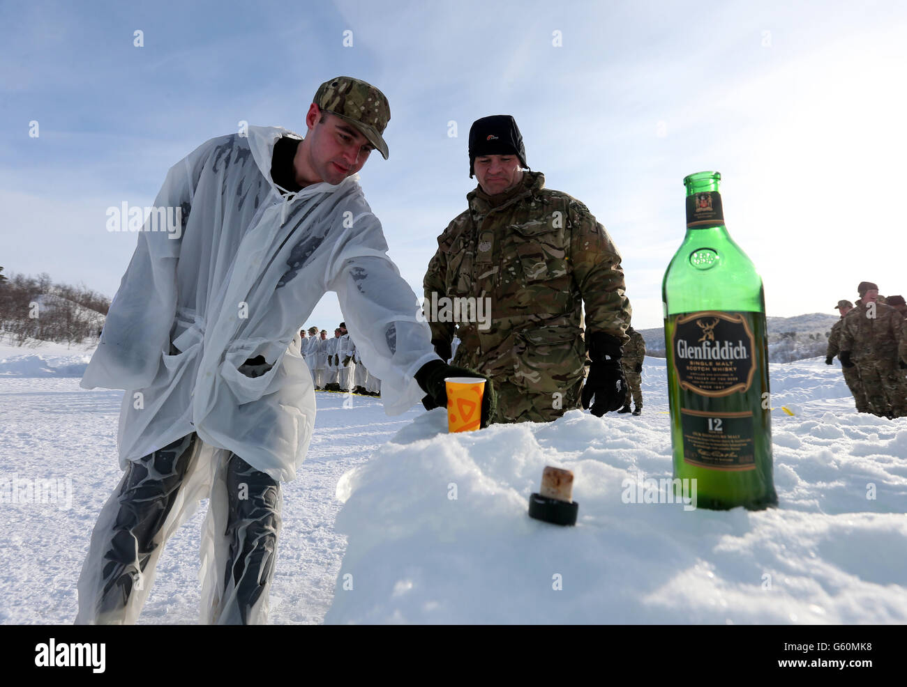 A Marine takes a drink of Whisky after he completed the ice breaking ...