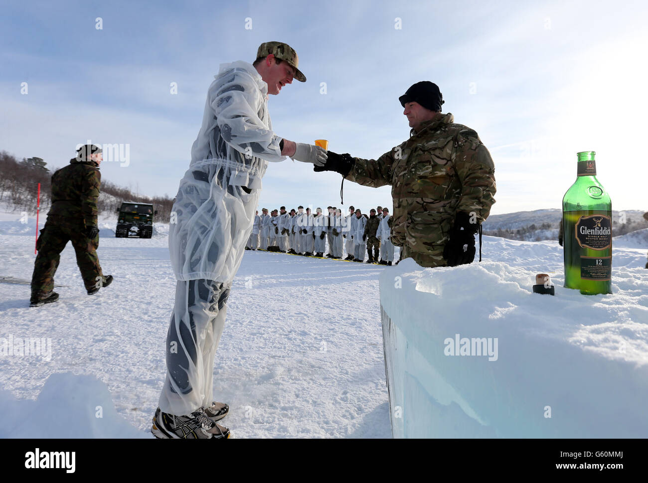 A Marine takes a drink of Whisky after he completed the ice breaking ...