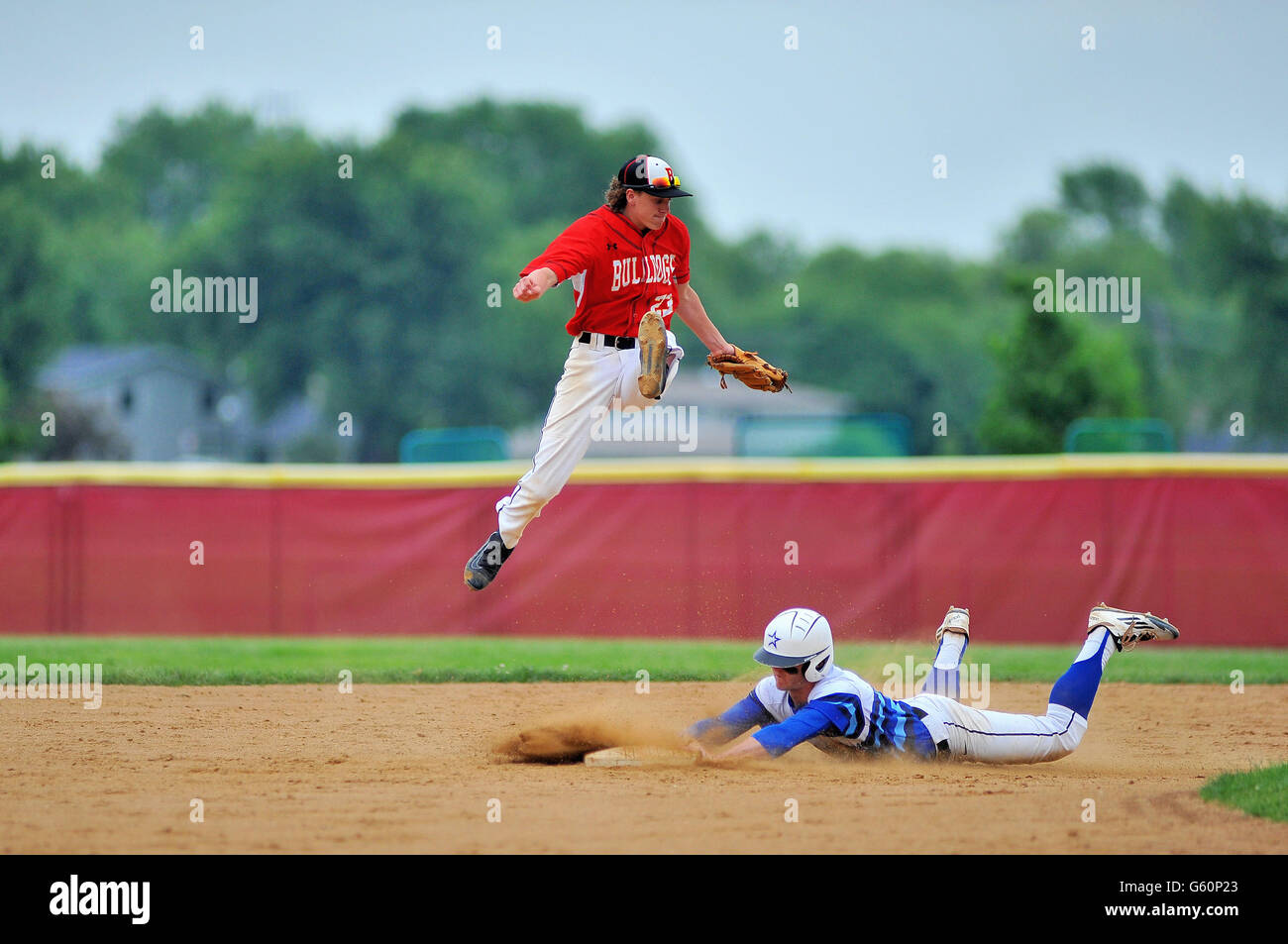 Middle infielder leaping high in the air to prevent a throw from going ...