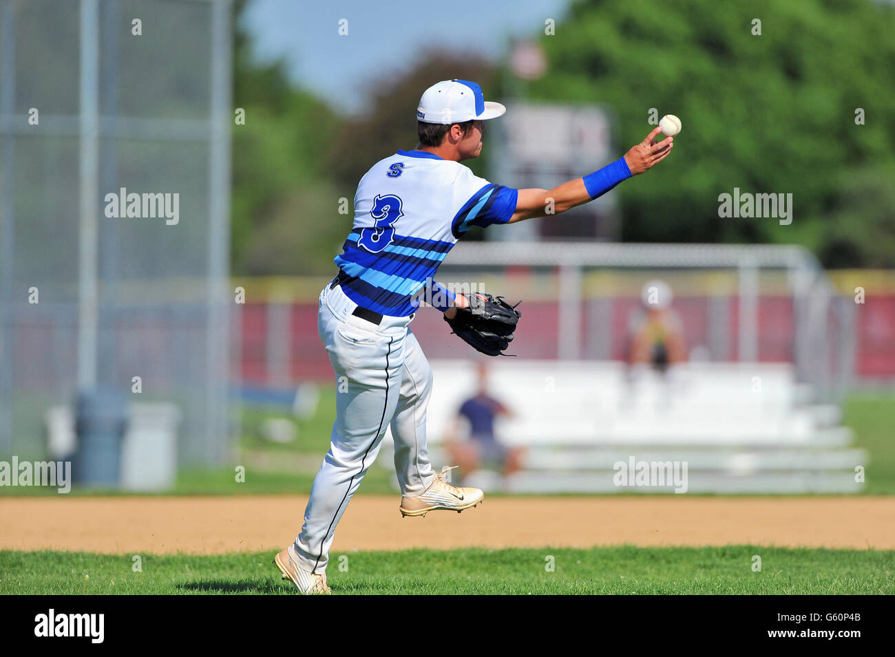 High school shortstop throwing to first base to retire an opposing ...