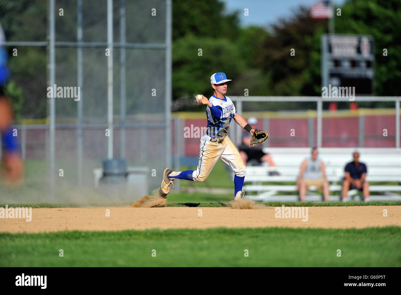A high school second baseman throwing on to first base to retire a ...