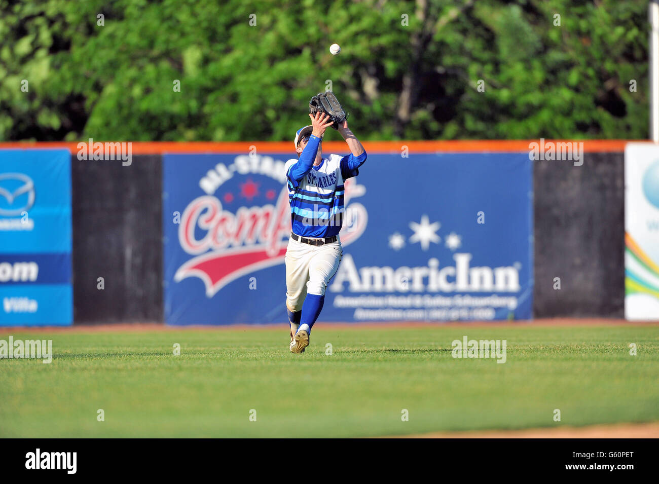 High school outfielder making a running catch to retire a hitter during ...