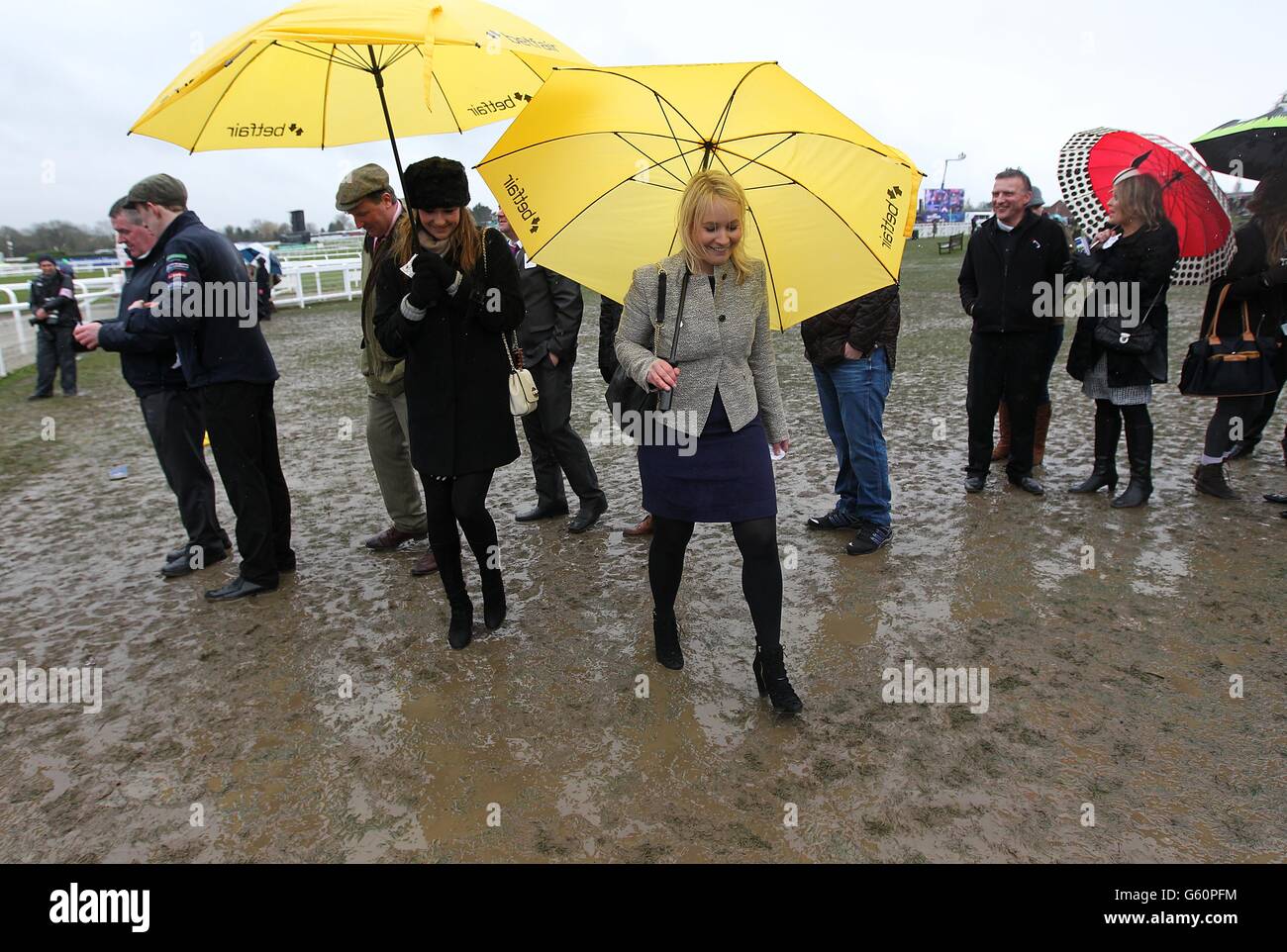Racegoers struggle in the rain and muddy conditions during Cheltenham ...