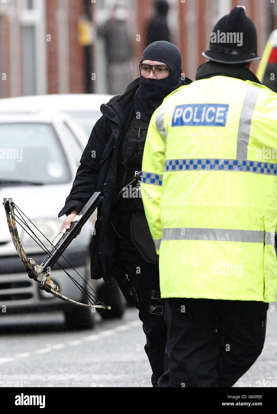 A police officer removes a crossbow from a property in the Trafford ...