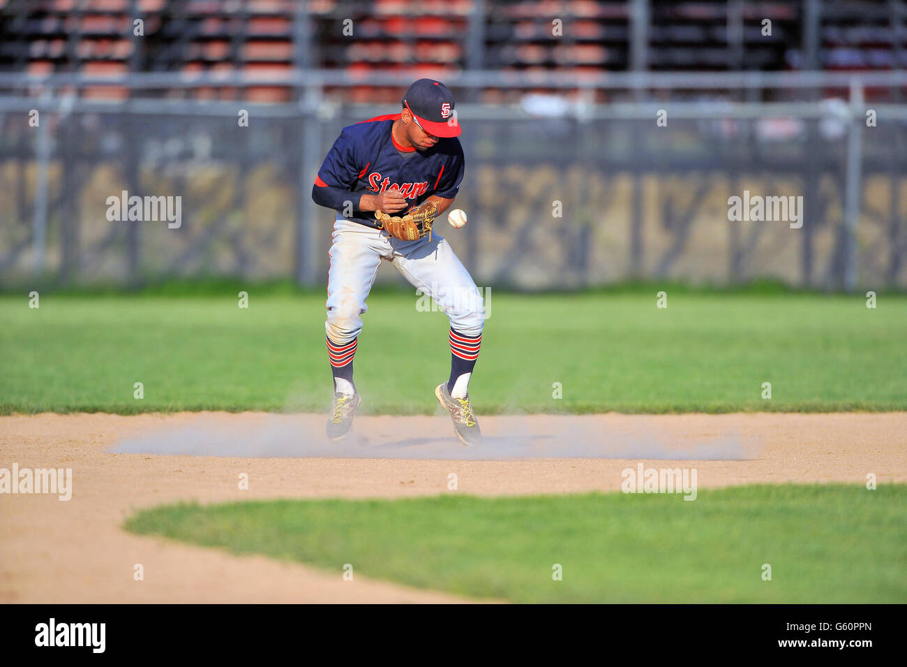High school infielder attempting to field a ground ball prior to ...