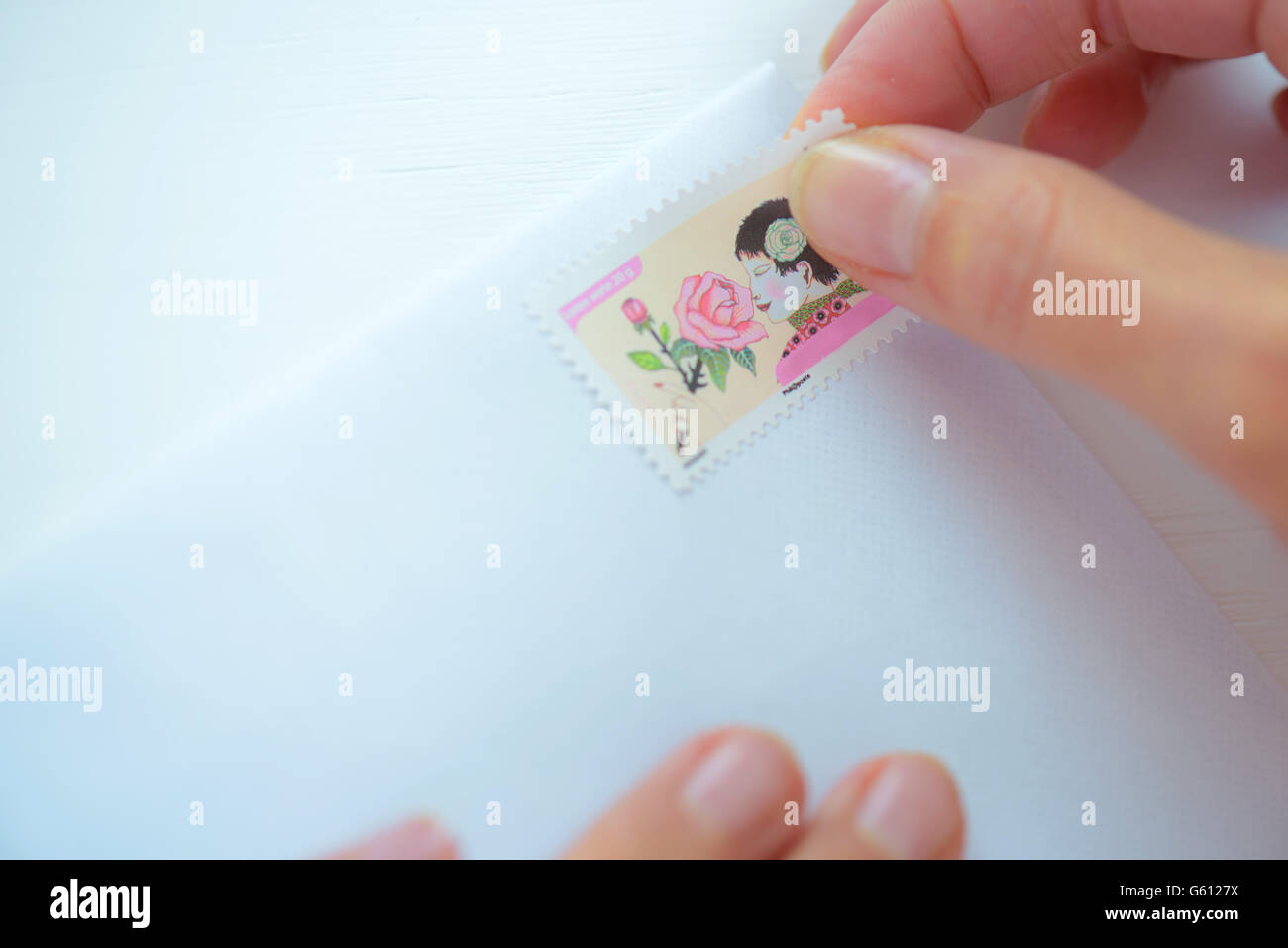 Putting a stamp on a letter Stock Photo - Alamy